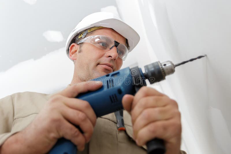 Male builder holds drill stock image. Image of occupation - 153019107