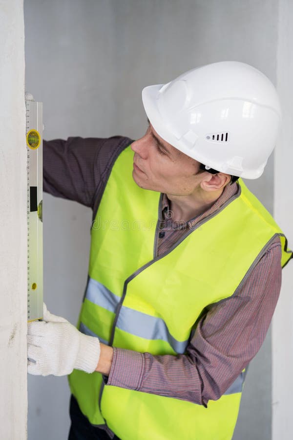 Male Builder Inspecting Wall with Level Tool Stock Photo - Image of ...