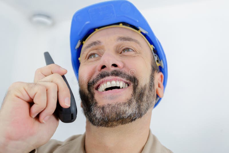 Male Builder Laughing while Talking on Walkie Talkie Stock Photo ...