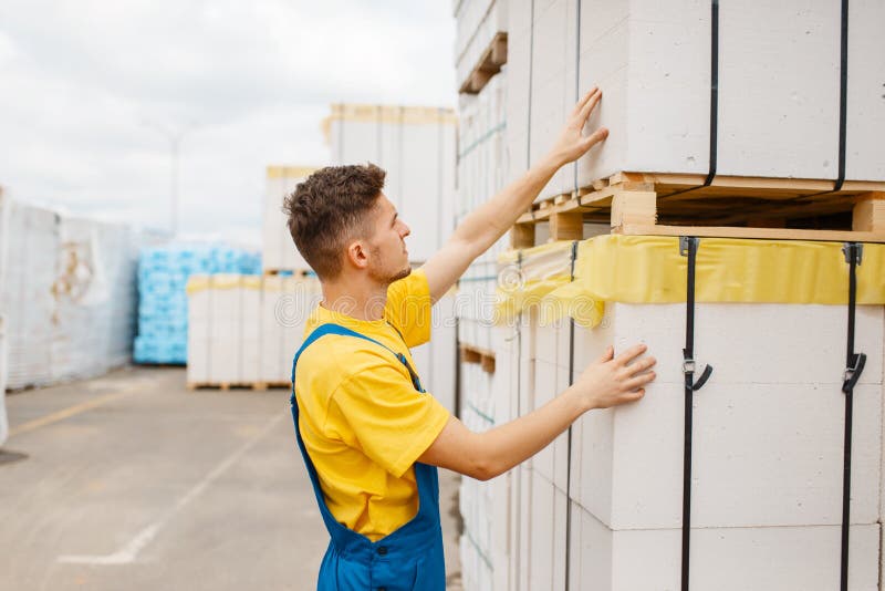 Builder between Big Pallets of Building Materials Stock Photo - Image ...
