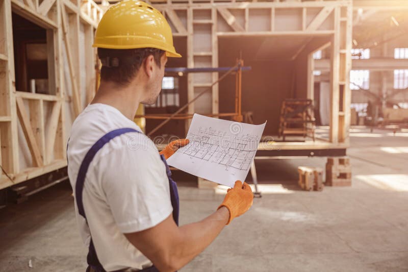 Male Builder Working with Architectural Plan at Construction Site Stock ...