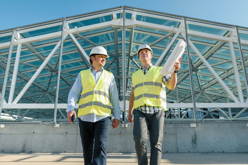 Male Builders Go Forward on Roof of Construction Site. Building ...