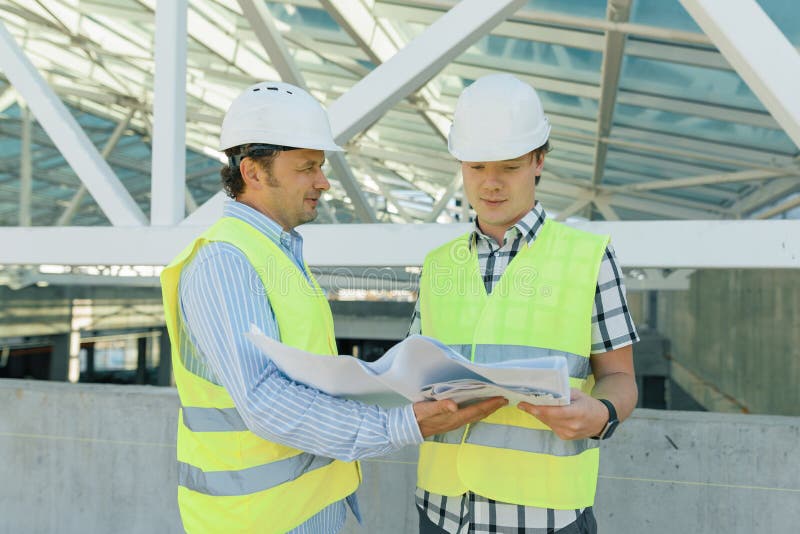 Male Builders on the Roof of Construction Site. Building, Development ...