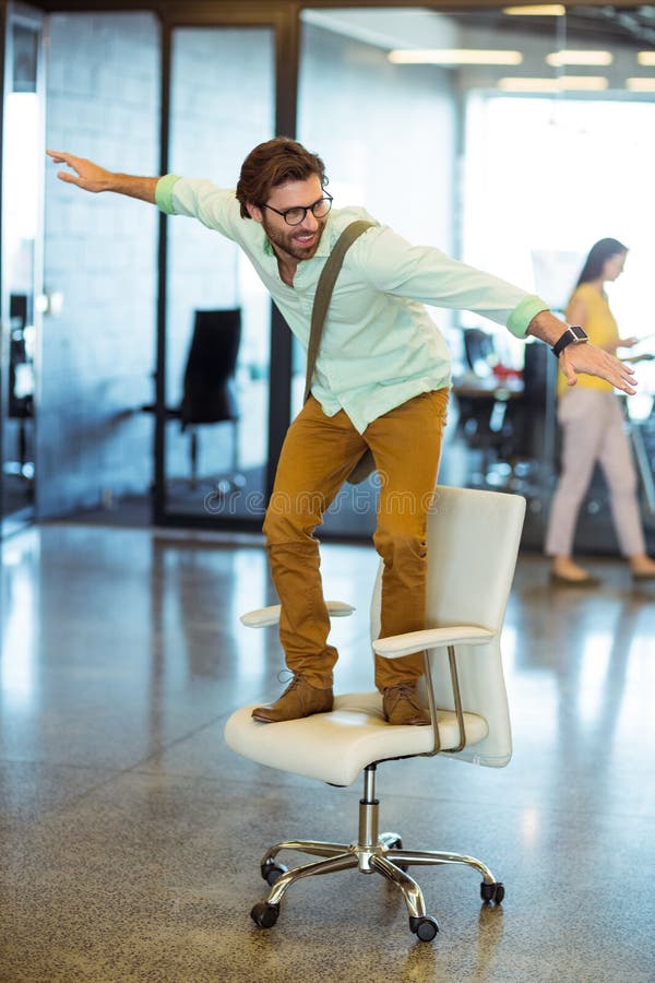 Man Standing With One Leg On Chair Touching Chin Stock Image - Image of ...