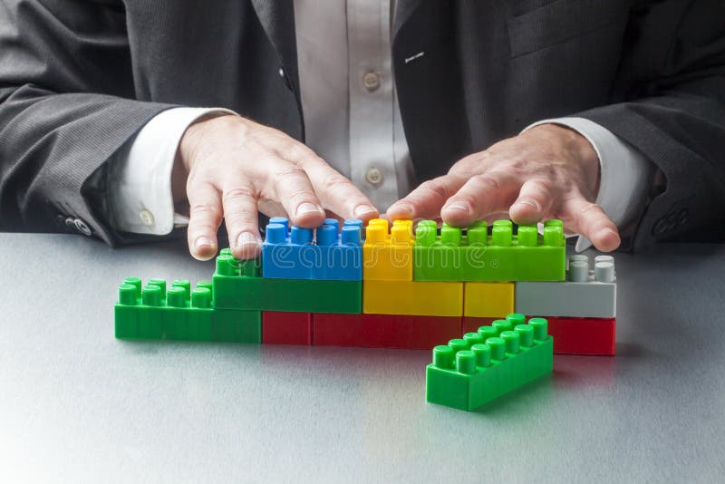 Male Businessman Playing with Kids Bricks As Teamwork Metaphor Stock ...