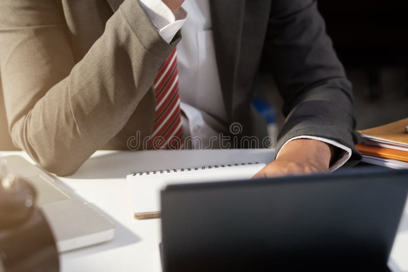 Male Businessman Use a Laptop Computer and Take Notes in the Notebook ...