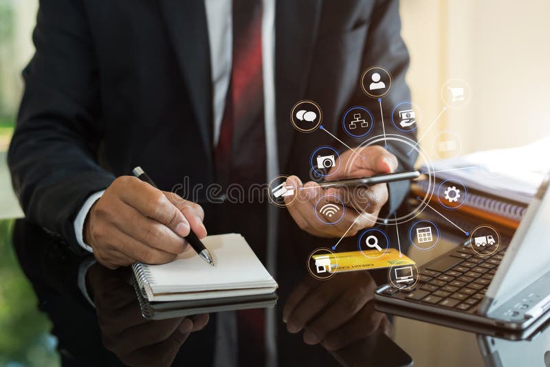 Male Businessman Use Smartphone and Take Notes in the Notebook. Stock ...