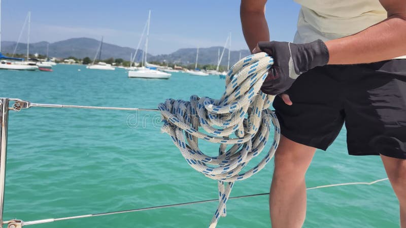 Male Captain on Deck of Sailboat Opening Sails Pulling the Rope Stock ...