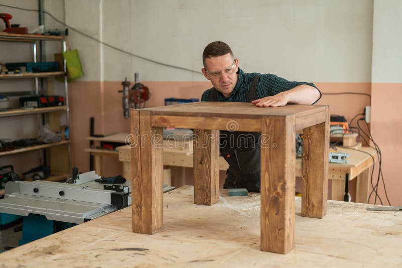 Male Carpenter Finishing Work on Wooden Table in Workshop. Stock Image ...