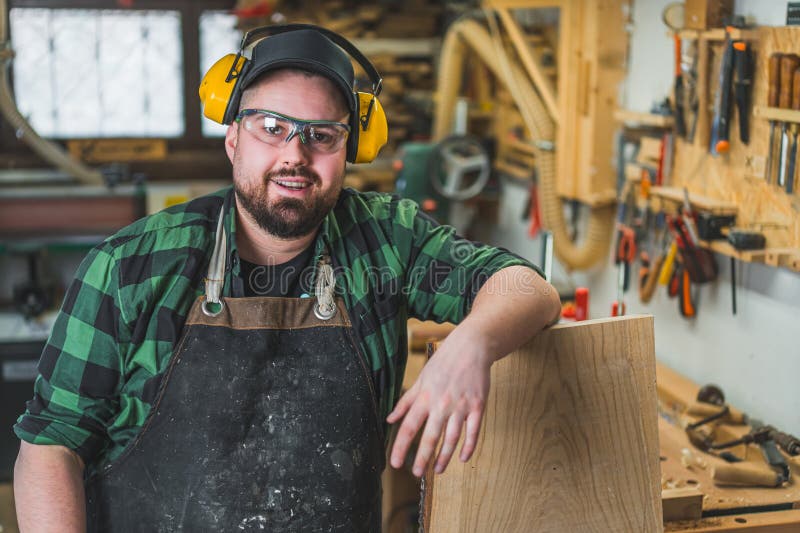 Male Carpenter with Protective Glasses and Headphones on Leaning ... Male Carpenter with Protective Glasses and Headphones on Leaning ...