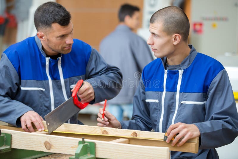 Male Carpenter Training Female Apprentice To Use Plane Stock Image ...