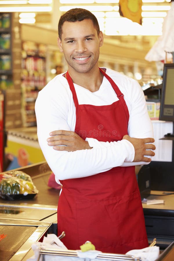 Male Cashier at Supermarket Checkout Stock Image - Image of apron ...