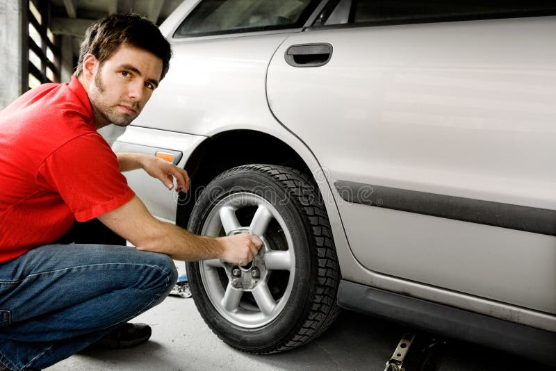 Male Changing Tire stock photo. Image of garage, person - 5080084