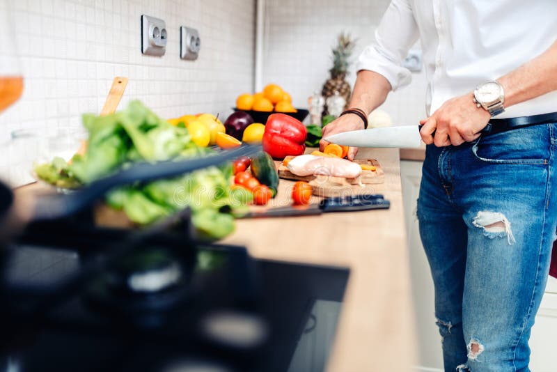 Male Chef Preparing Dinner with Chicken Breast and Cutting Vegetables ...