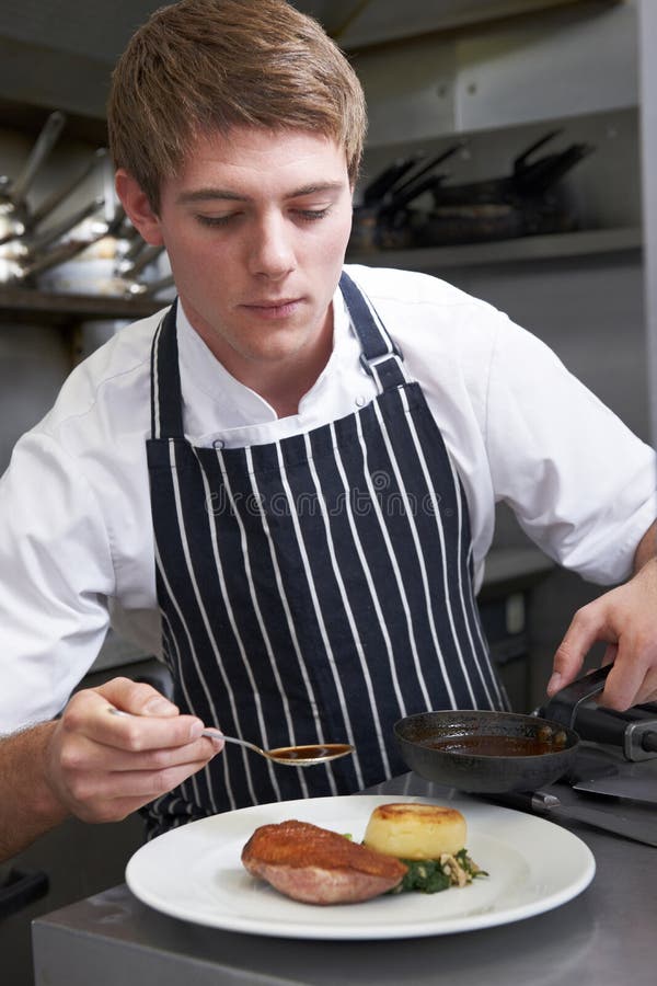 Male Chef Preparing Meal In Restaurant Kitchen. - Stock Image - Everypixel