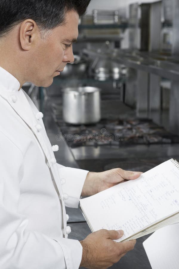 Male Chef Reading Recipe Book in Kitchen Stock Photo - Image of ...