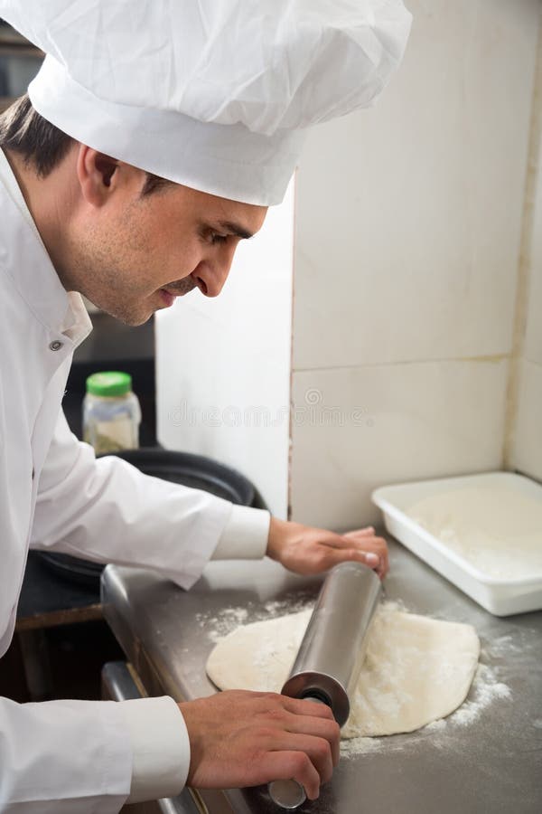 Male chef rolls dough stock photo. Image of clothing - 71652894