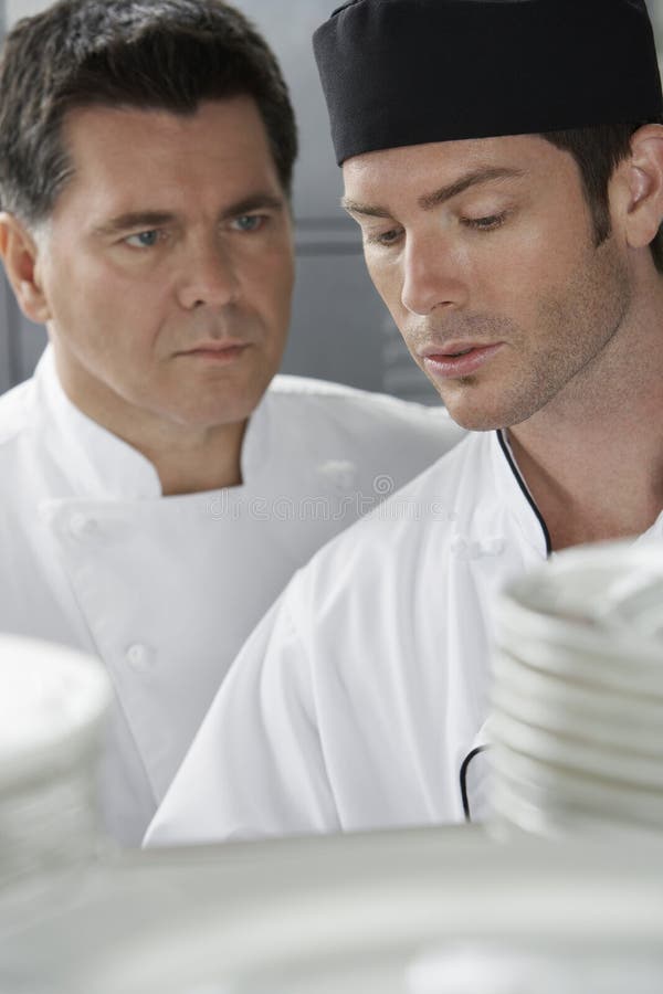 Male Chef Supervising Trainee in Kitchen Stock Photo - Image of ...