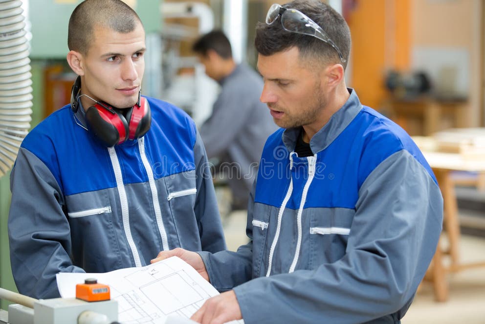 Male Colleagues Looking at Paperwork in Carpentry Workshop Stock Photo ...