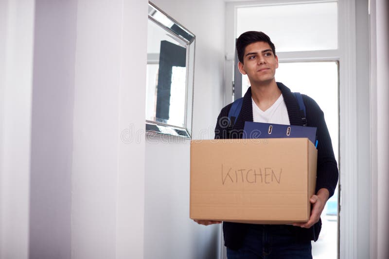 Male College Student Carrying Box Moving into Accommodation Stock Photo ...
