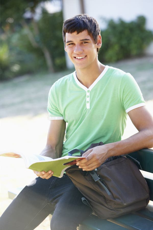 Male College Student Sitting on Bench with Book Stock Photo - Image of ...