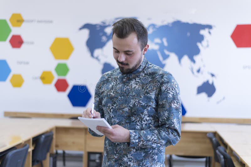 Male College Student Standing Inside Classroom and Using Tablet and ...