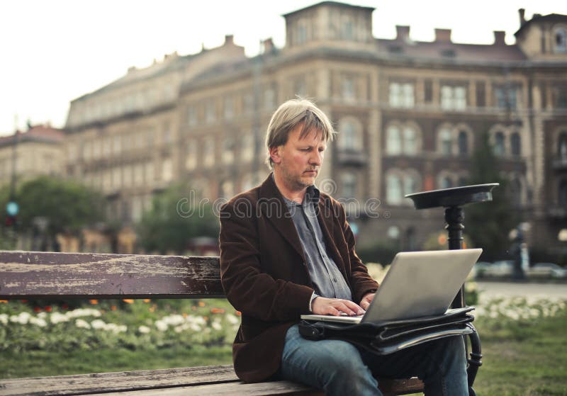 Male with a Computer on a Bench in the City Stock Photo - Image of ...