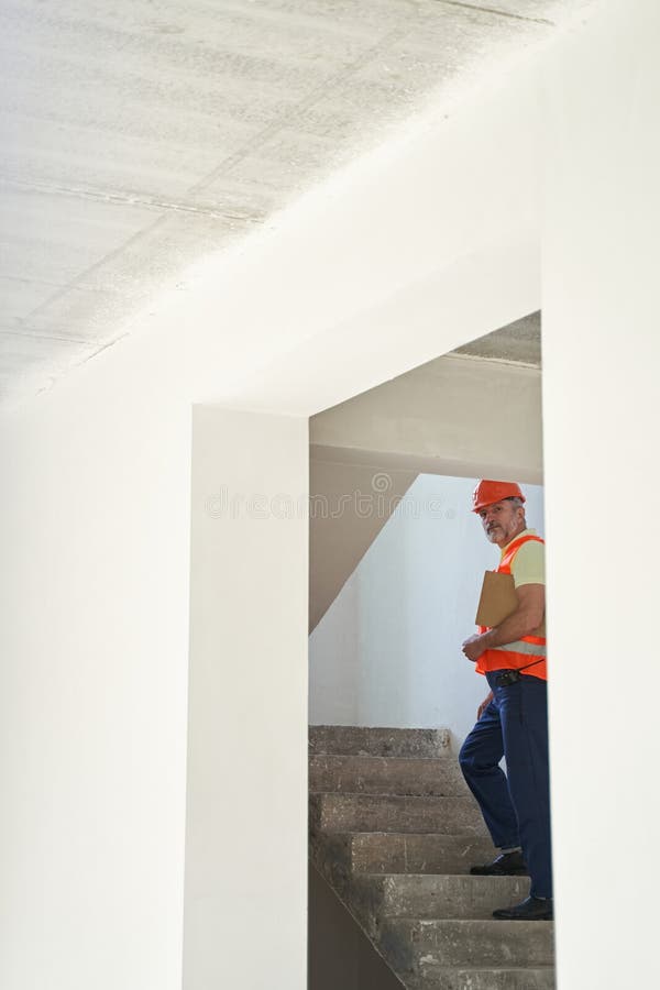 Male Construction Worker Going Up the Stairs with Notepad Stock Photo ...