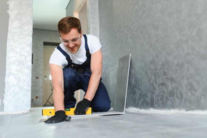 A Male Construction Worker Installs a Large Ceramic Tile Stock Photo ...