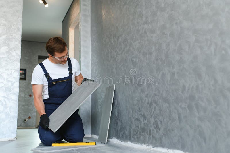 A Male Construction Worker Installs a Large Ceramic Tile Stock Image ...