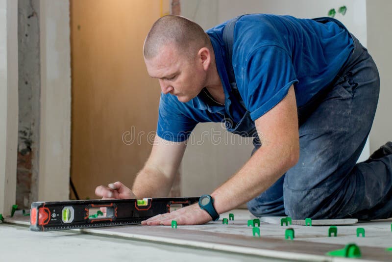 A Male Construction Worker Installs a Large Ceramic Tile Stock Image ...