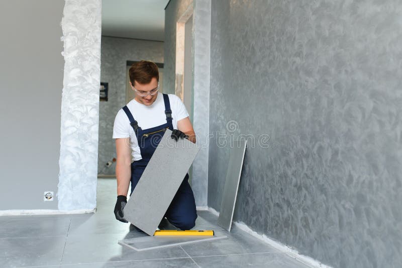 A Male Construction Worker Installs a Large Ceramic Tile Stock Photo ...