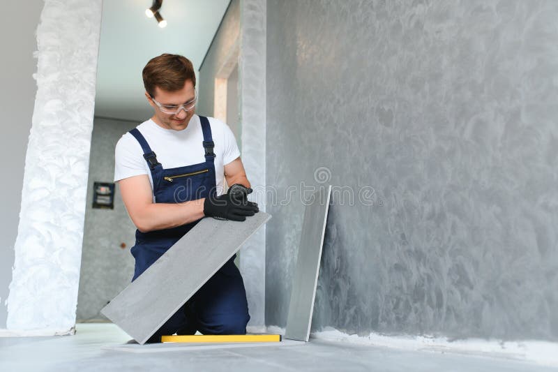 A Male Construction Worker Installs a Large Ceramic Tile Stock Photo ...