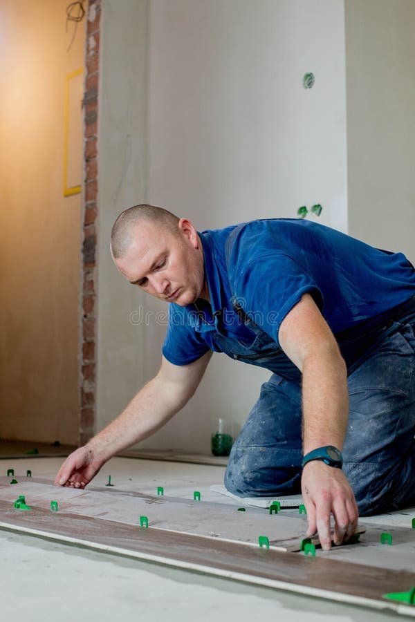 A Male Construction Worker Installs a Large Ceramic Tile Stock Photo ...