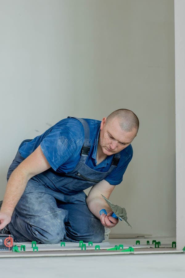 A Male Construction Worker Installs a Large Ceramic Tile Stock Image ...