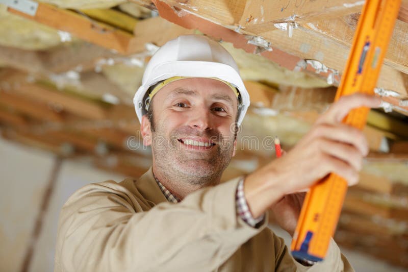 Male Construction Worker Using Level To Measure Grade Ceiling Stock ...
