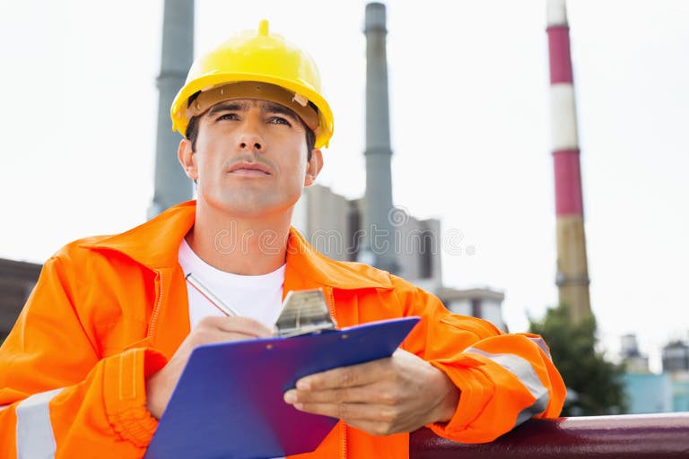 Male Construction Worker Writing on Clipboard at Industry Stock Image ...