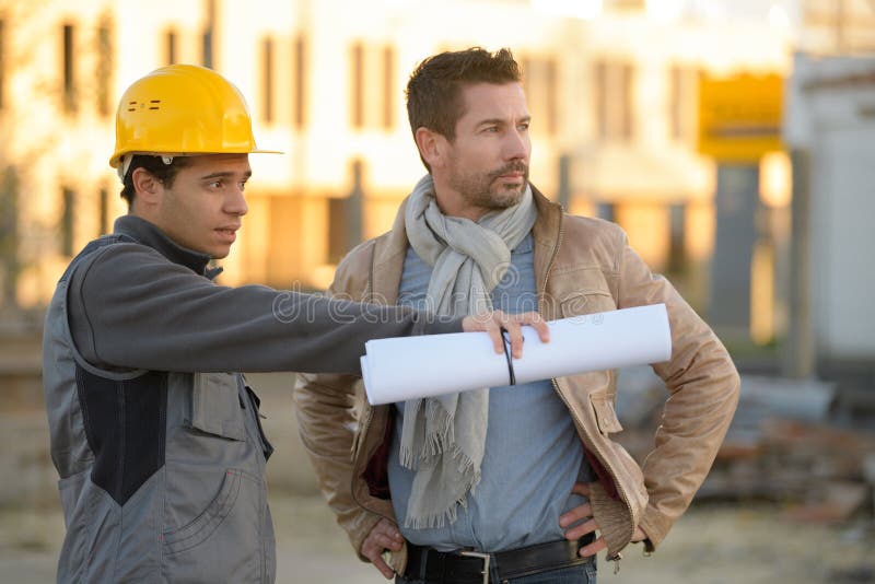 Male Construction Workers Pointing at House Stock Image - Image of ...