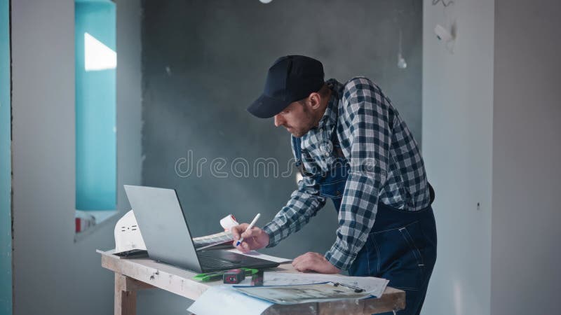 A Male Contractor Builder at a Construction Site, Working with a ...
