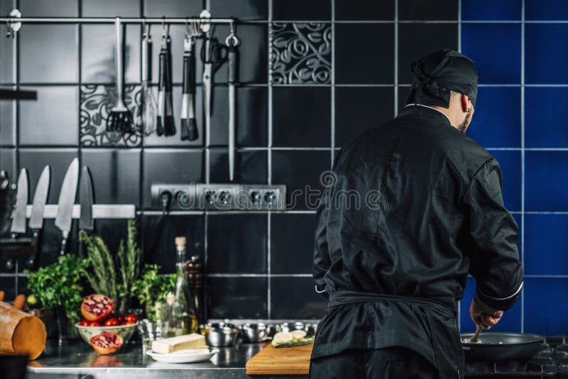 Male Chef from Behind, Peppering Food in a Kitchen Stock Photo - Image ...