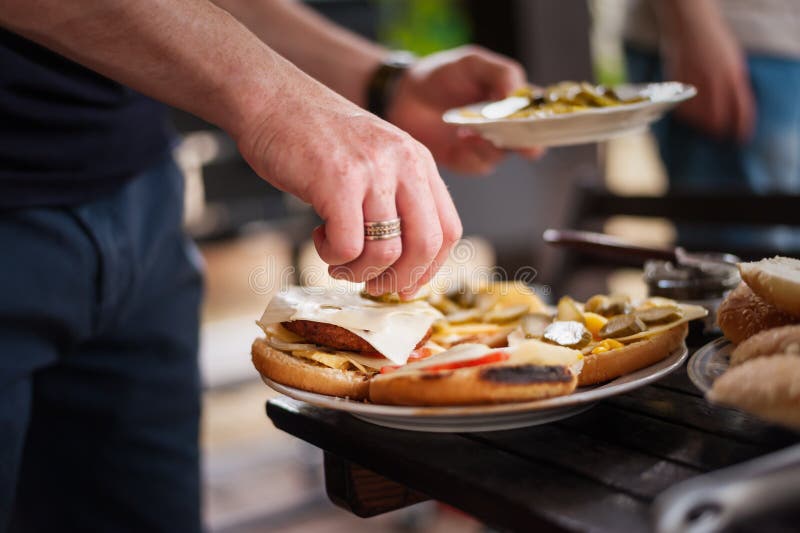 Male Cook in Process of Making Burger. Male Chef Place a Cheese on a ...