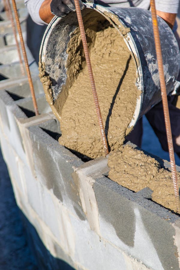 Male Craftsman Pouring Concrete into Concrete Bricks. Selective Focus ...