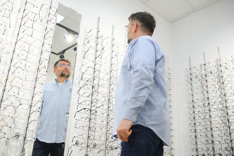 Male Customer Choosing Glasses in Optics Store Stock Photo - Image of ...