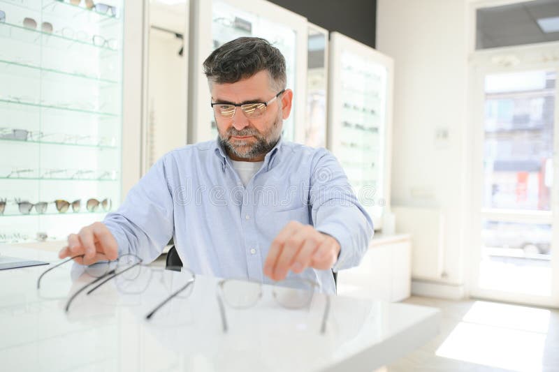 Male Customer Choosing Glasses in Optics Store Stock Photo - Image of ...