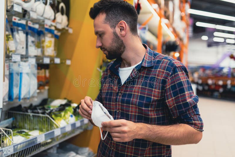 Male Customer in a Hardware Store Chooses a Mask for Painting Work ...