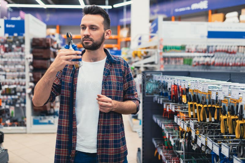A Male Customer in a Hardware Store in the Tool Department Chooses Wire ...