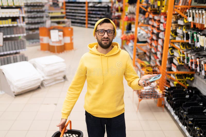 A Male Customer is Lost in a Hardware Store among a Wide Range of Goods ...
