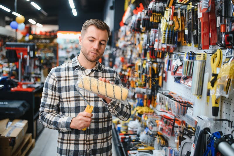 A Male Customer in a Modern Hardware Store Chooses a Paint Roller Stock ...