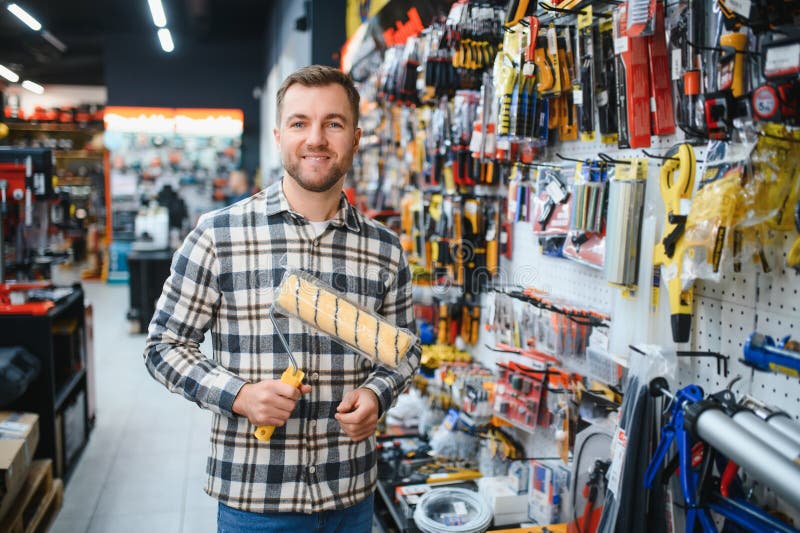 A Male Customer in a Modern Hardware Store Chooses a Paint Roller Stock ...