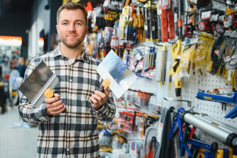 A Male Customer in a Modern Hardware Store Chooses Trowels Stock Image ...